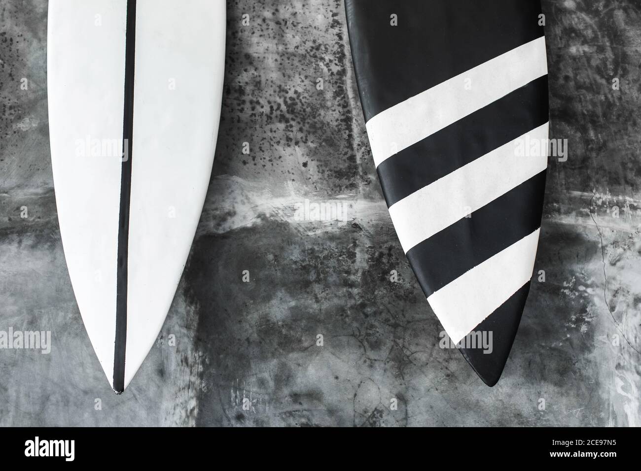 Black and white color surf board on gray concrete wall background ...