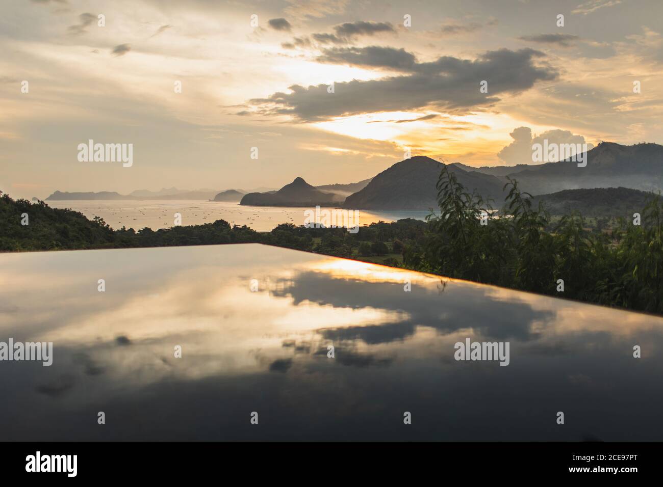 Infinity pool with amazing mountain and ocean view at sunset. Cloud ...