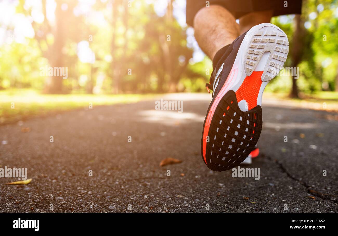 sporty man runner running on roads in the park with soft-focus and over ...