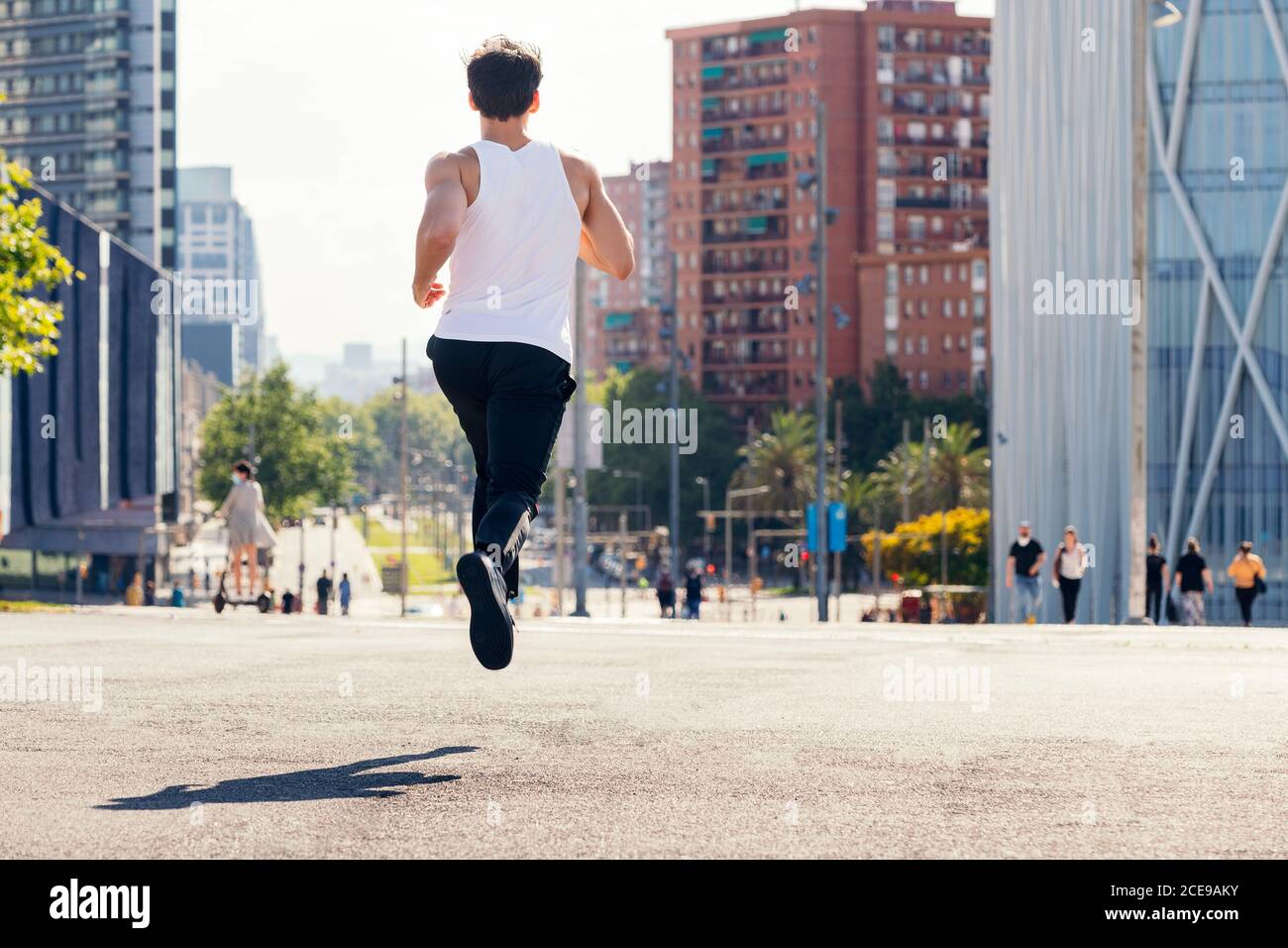 rear view of a runner running on the asphalt in the city, concept of ...