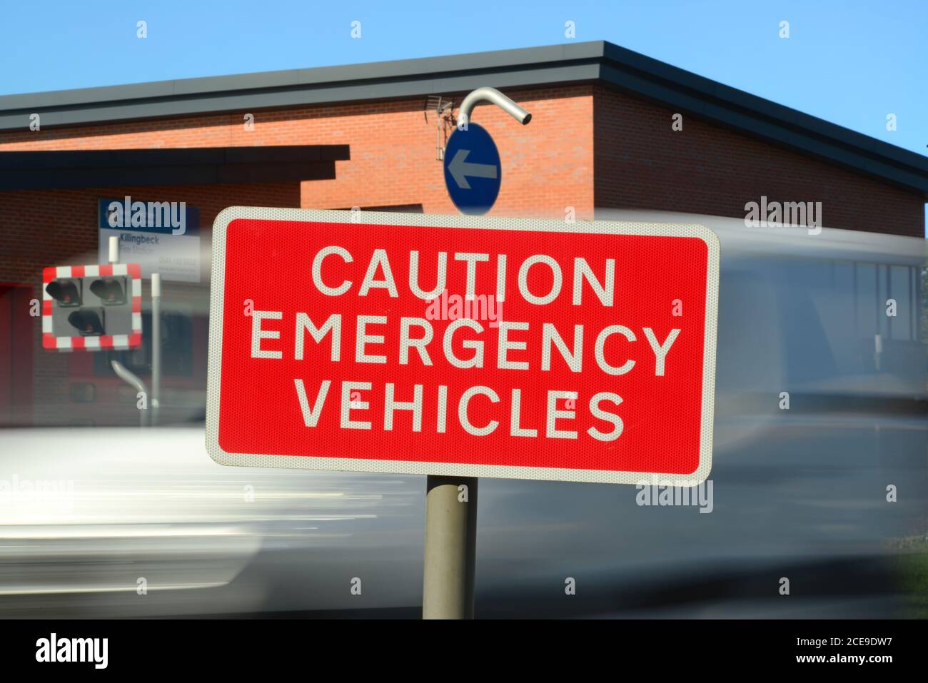 caution emergency vehicles warning sign and lights outside fire station ...