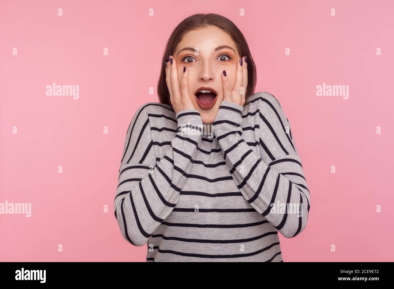 Wow, unbelievable! Portrait of excited surprised woman in striped ...