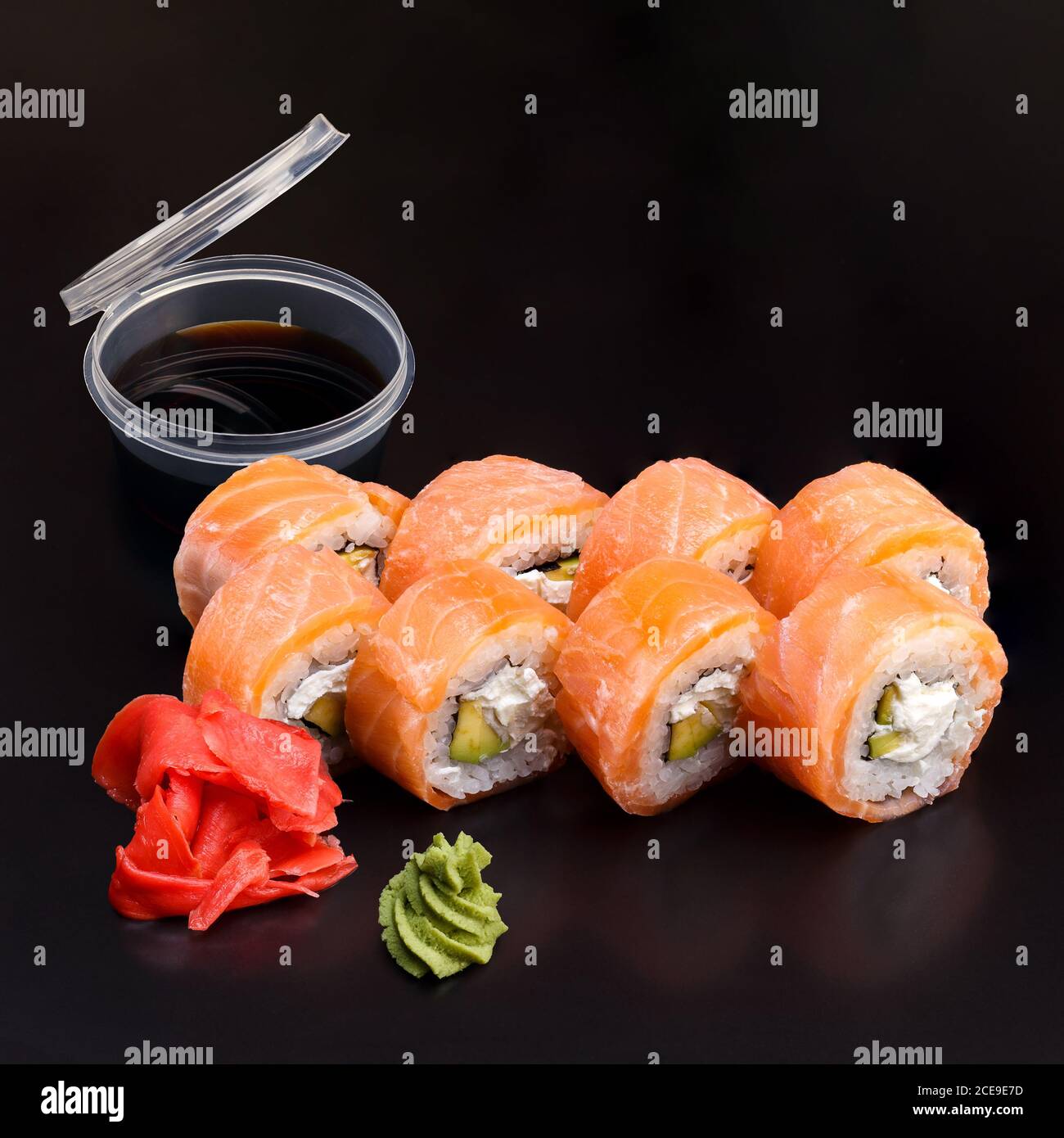 Traditional delicious fresh sushi roll set on a black background with ...