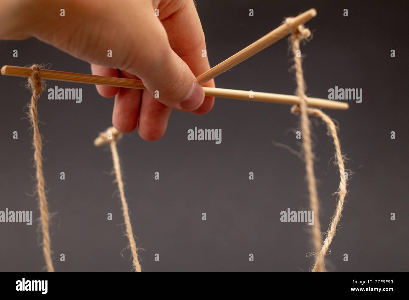 Puppet master hand controlling and manipulating on black background ...