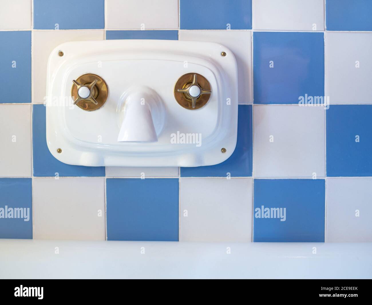 Antique interior water tap in the bathroom on the blue and white tile ...