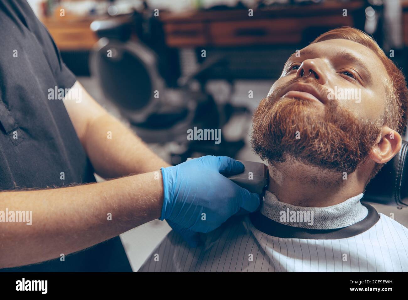 Close up man getting hair cut at the barbershop wearing mask during ...