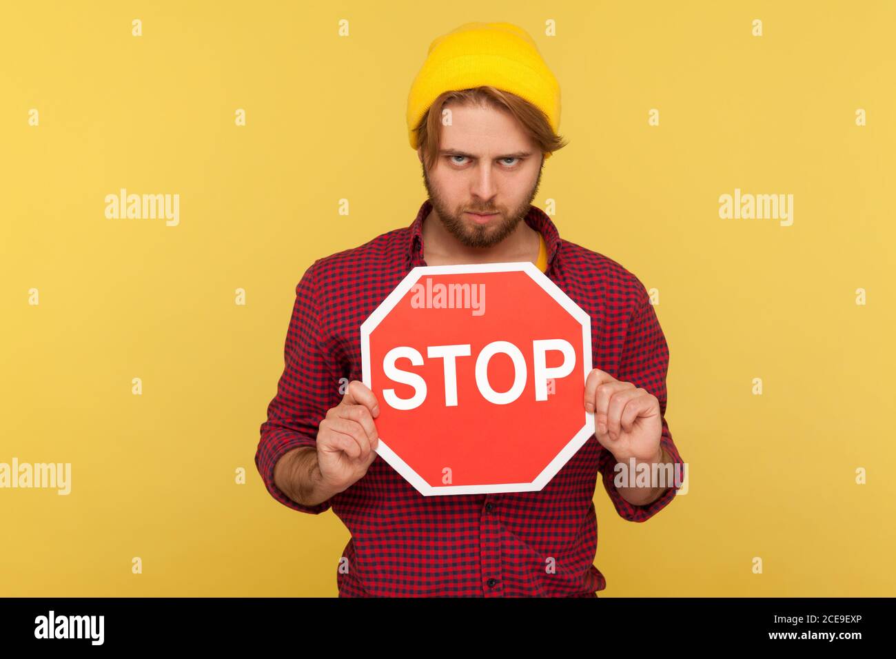 Determined serious hipster guy in beanie hat and checkered shirt ...