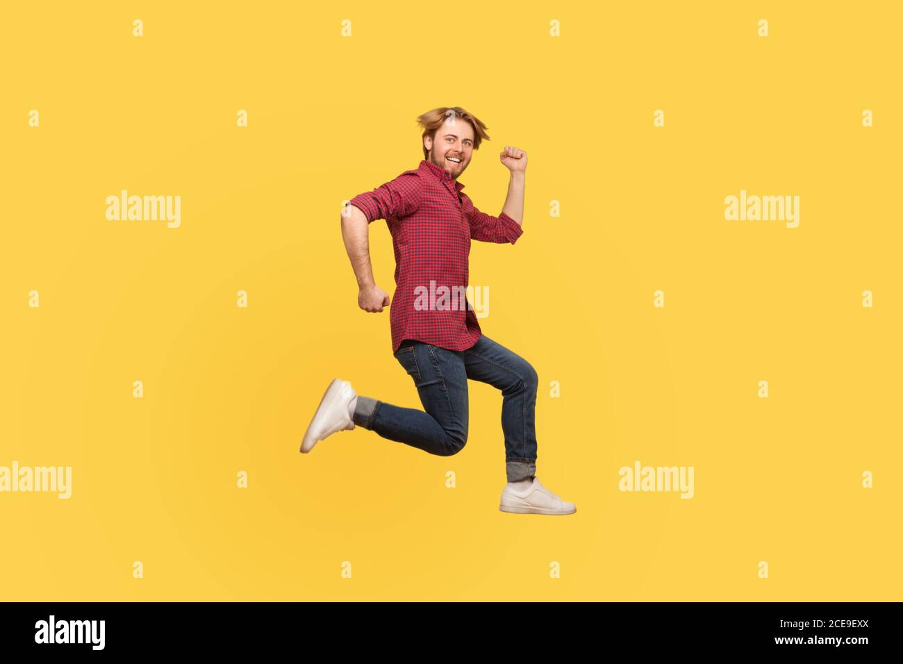 Enthusiastic happy lively guy in casual outfit jumping high trampoline ...