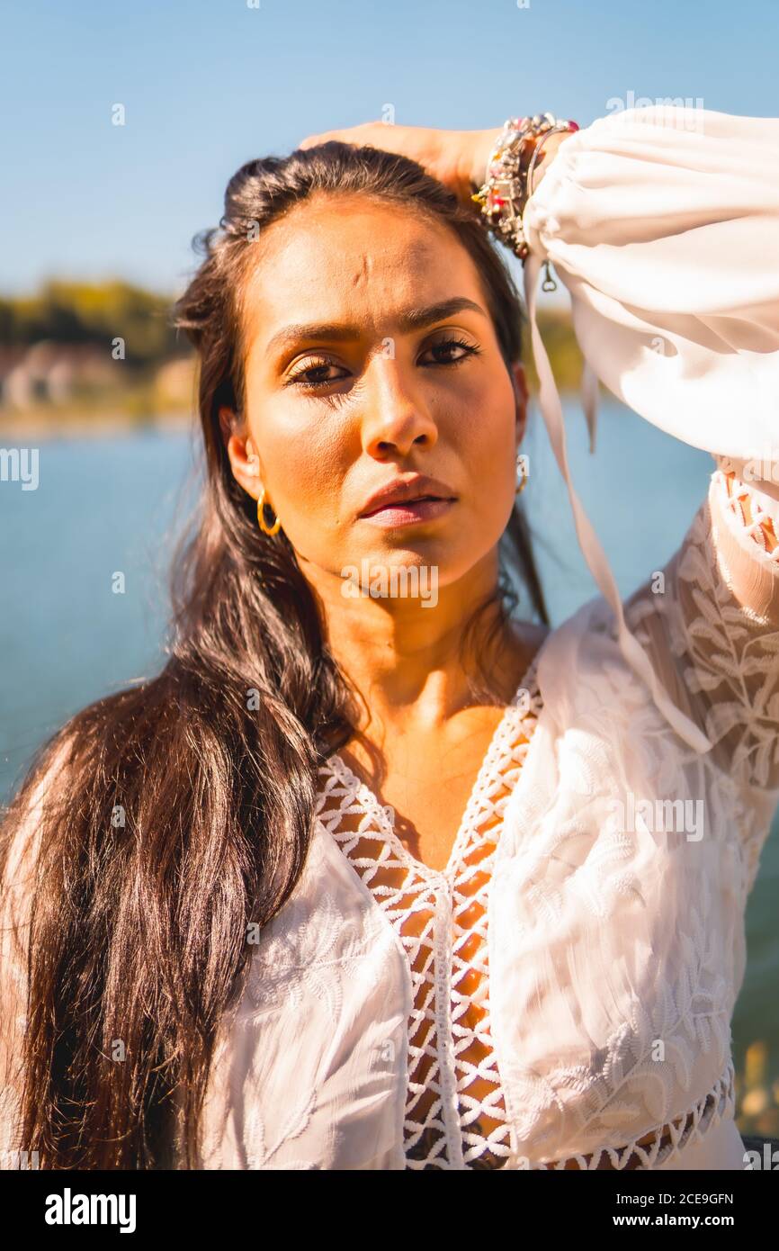 Closeup portrait of a beautiful young Hispanic female in white dress ...