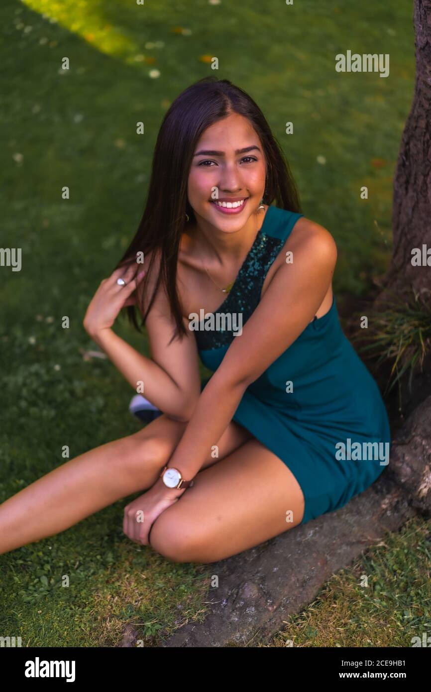 Beautiful Hispanic female wearing a turquoise dress sitting next to a ...