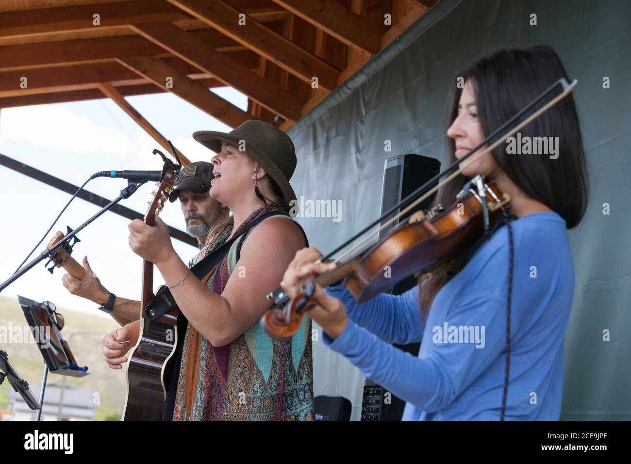 Sally Newsome-Ladd (center), accompanied by John Cotton on guitar and ...