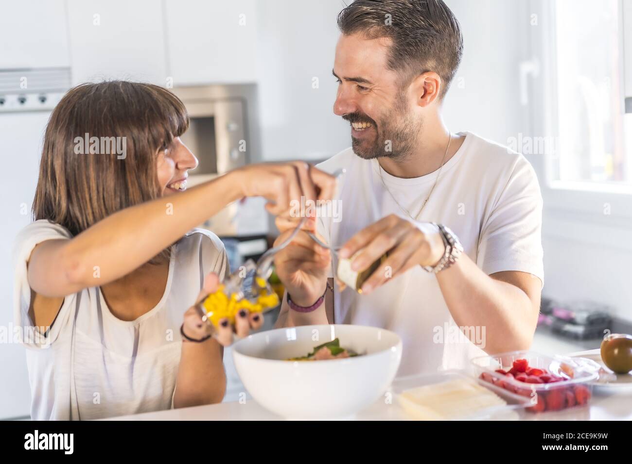 Happy couple cooking together at the kitchen Stock Photo - Alamy