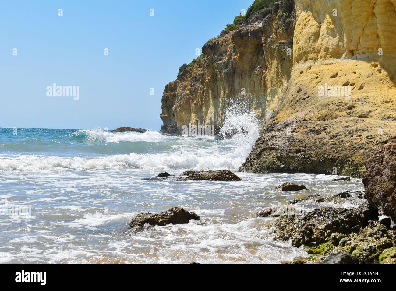 A beautiful shot of a beach with rocky mountains alongside, Cala Fonda ...