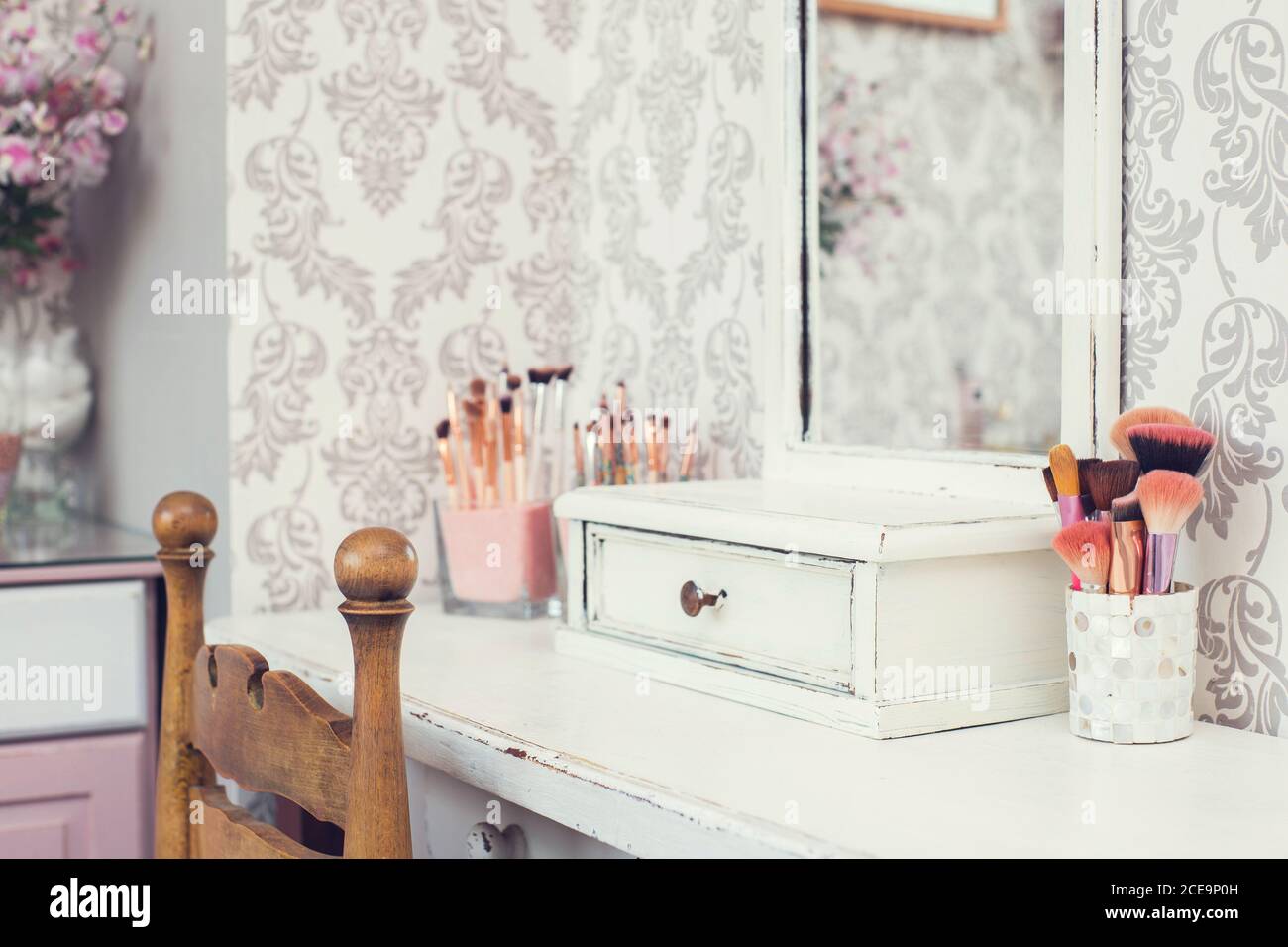 female makeup table with makeup including brushes and mirror. pink ...