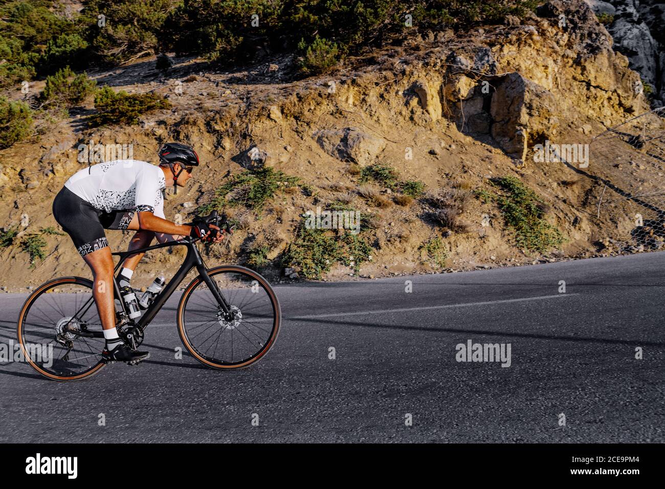 Professional road bicycle racer in action on mountain road Stock Photo ...