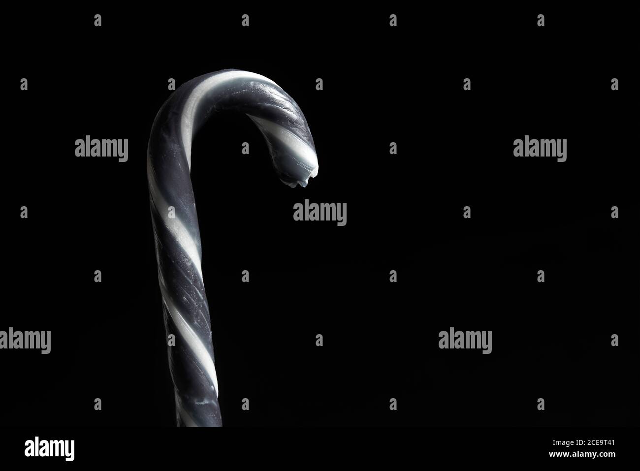 Halloween black and white striped candy cane on black background with ...