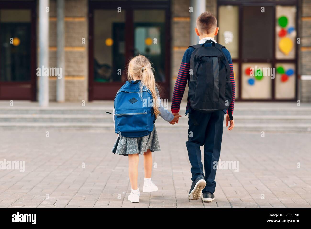 Two elementary students brother and little sister going back to school ...