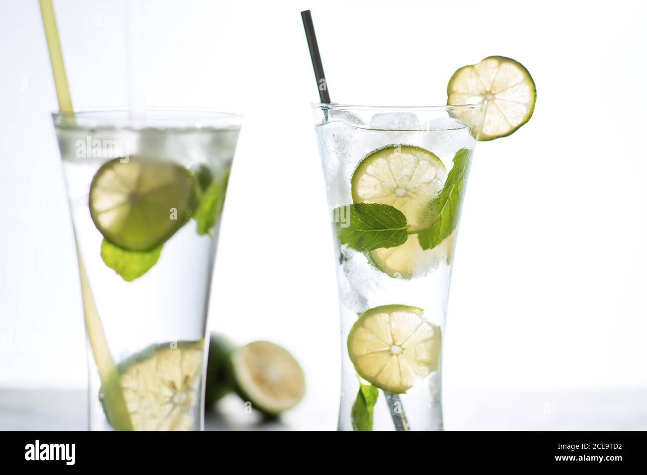 Cold refreshing beverage with sliced lime ripes and ice reverse light image in studio with white ...