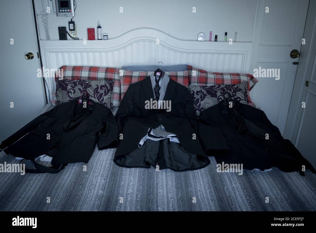 High angle shot of black wedding suits on the bed Stock Photo - Alamy