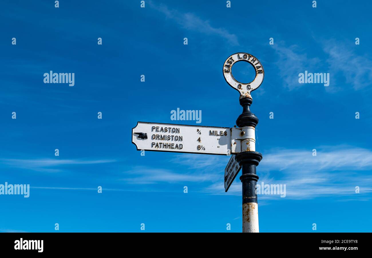 Old fashioned signpost with hand pointing to villages with distances in ...