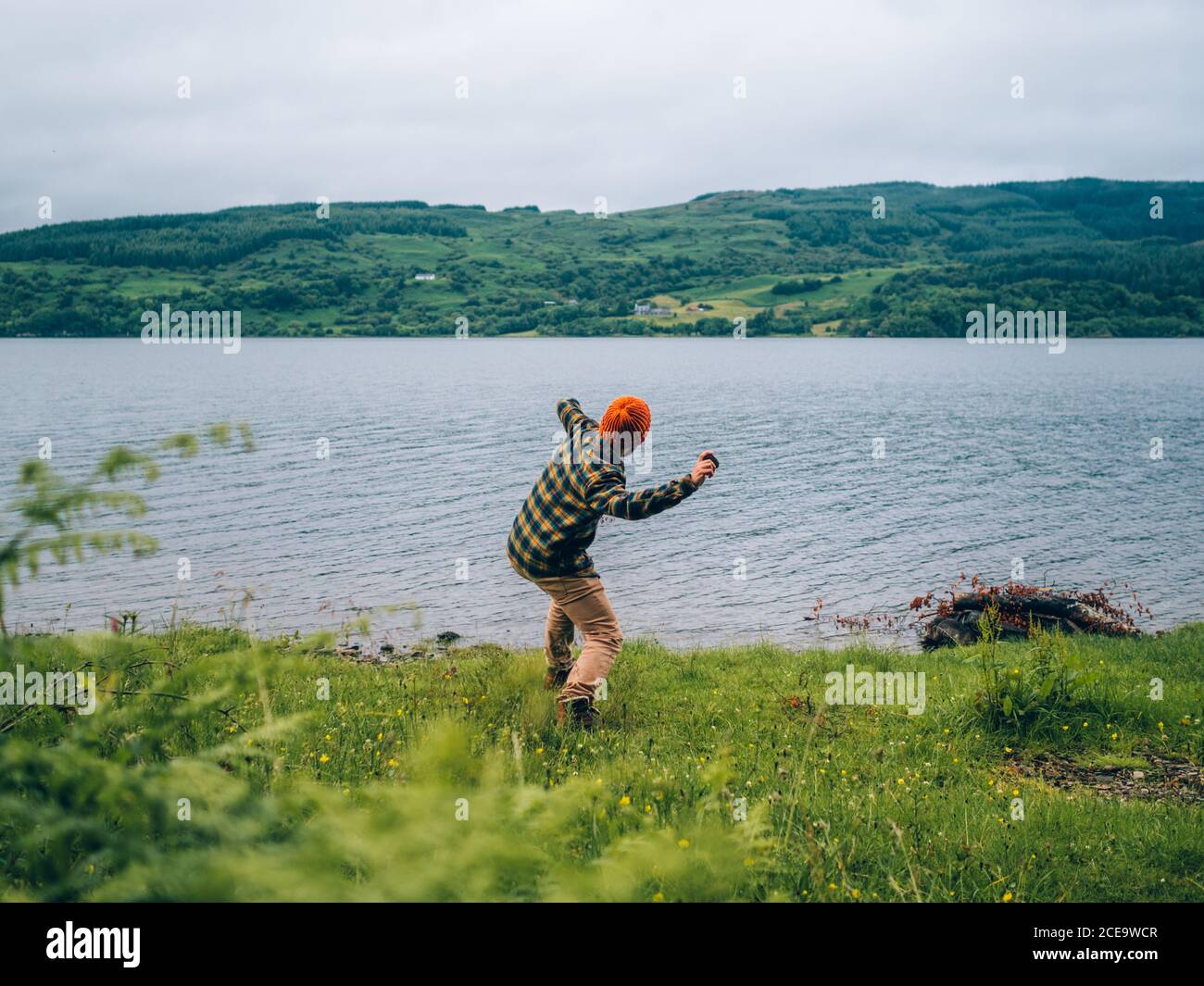 unrecognizable person throwing stone in water Stock Photo - Alamy
