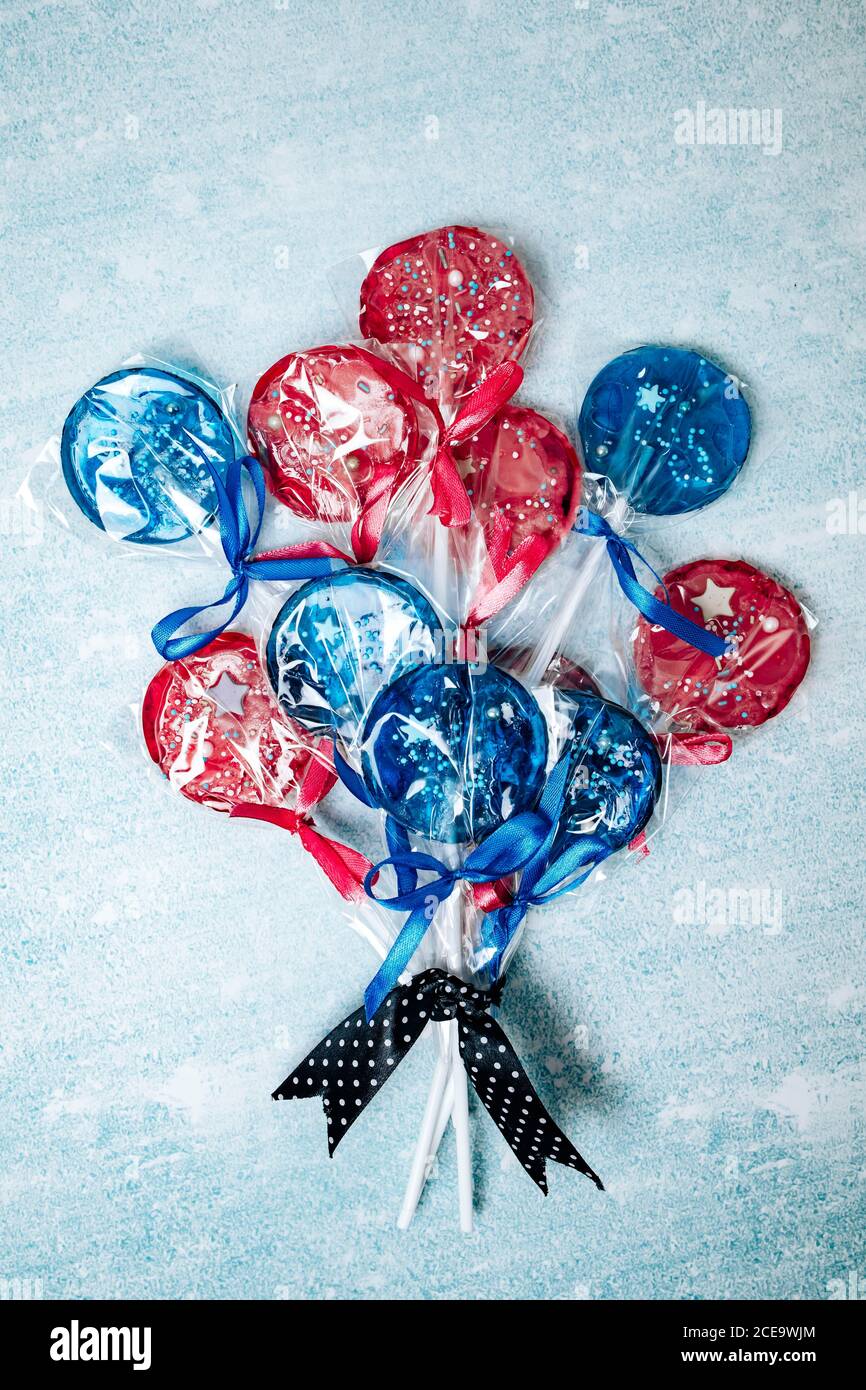 Blue and red lollipops forming a bouquet on blue background ...