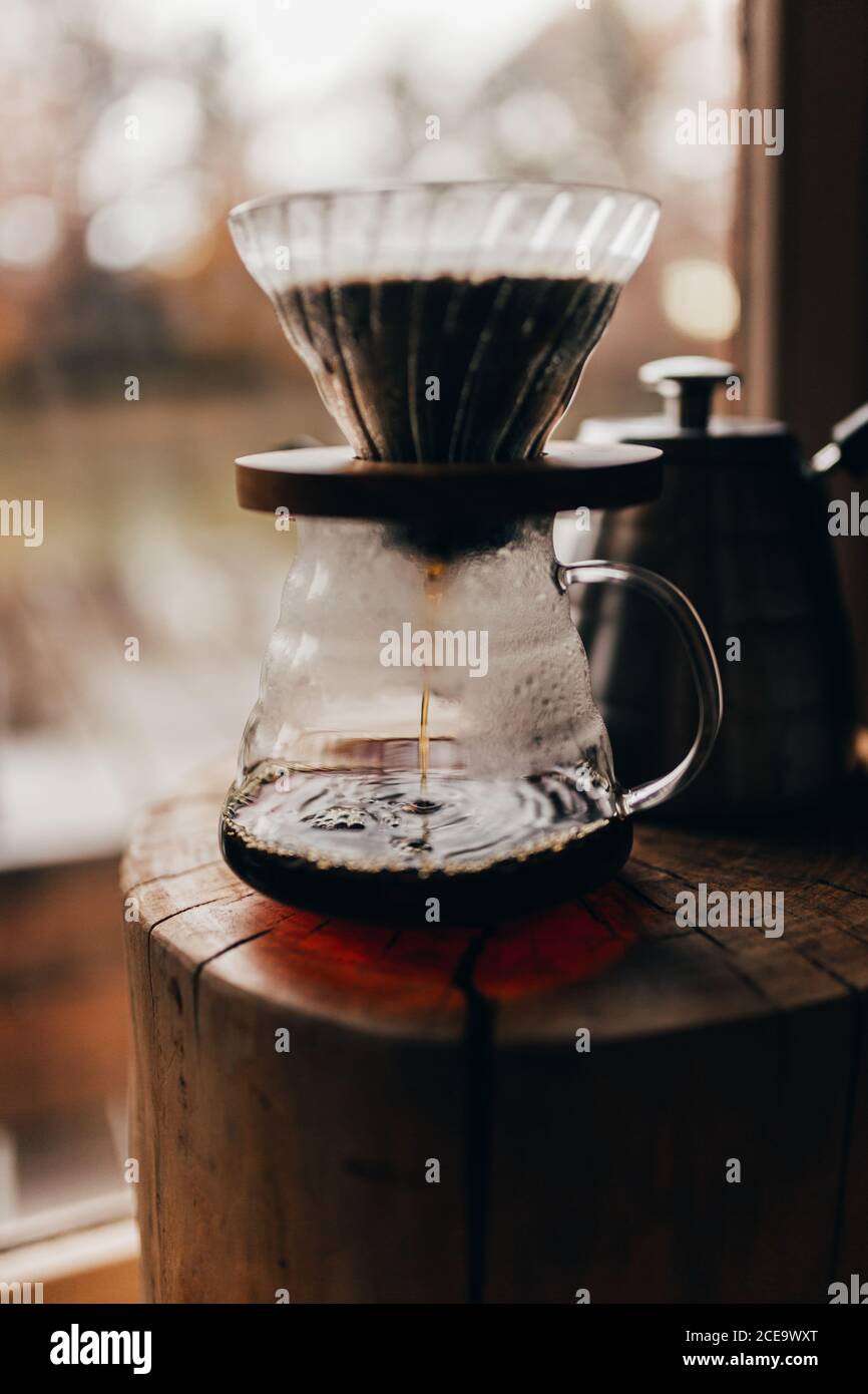 Fresh brewed coffee pouring to glass jug at home Stock Photo - Alamy