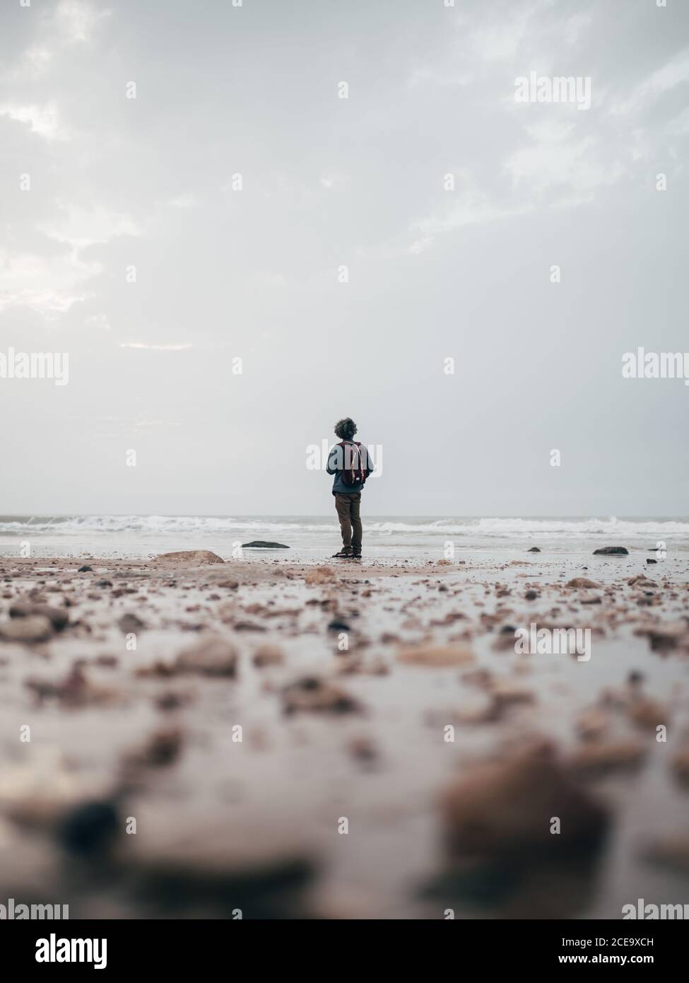 Tourist standing at calm ocean Stock Photo - Alamy