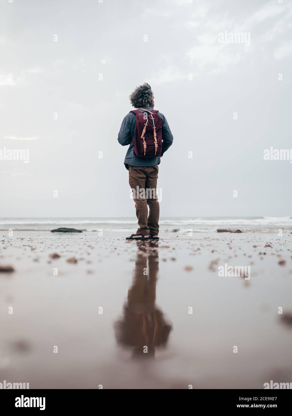 Tourist standing at calm ocean Stock Photo - Alamy