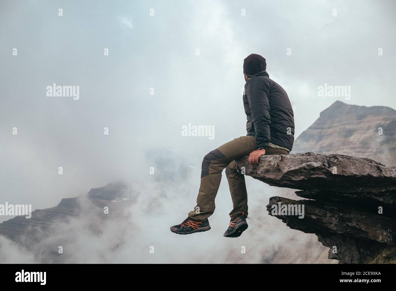 Side view male sitting on stone and looking at Castro Valnera mountain ...