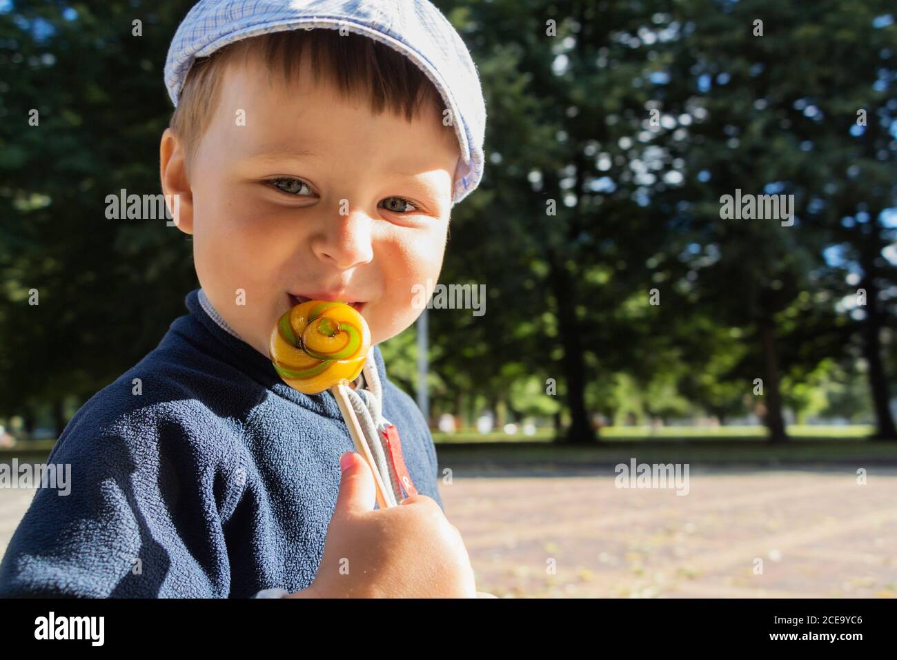 The boy is eating a delicious lollipop.A cute boy licks a lollipop ...
