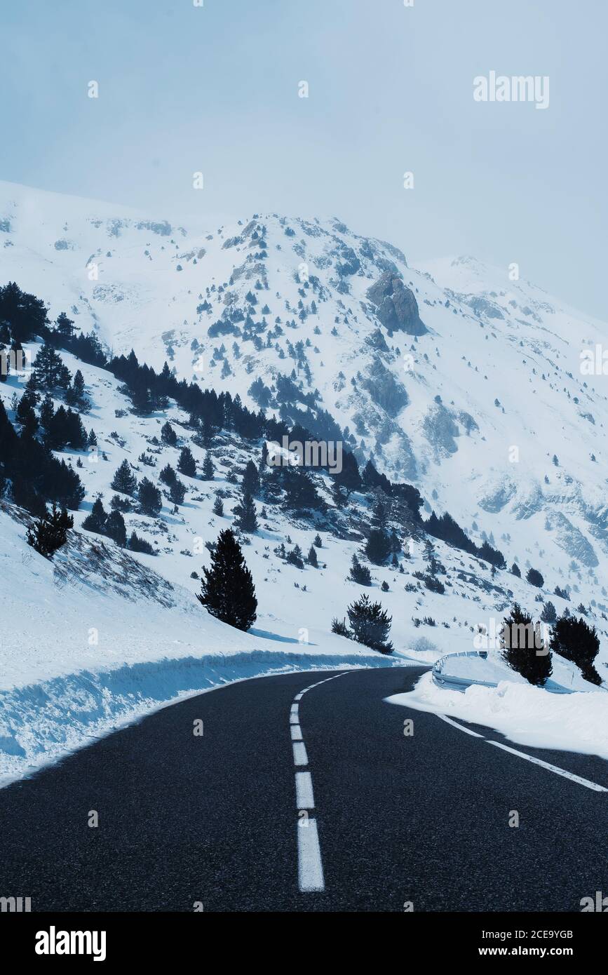 Empty road in snowy mountains Stock Photo - Alamy