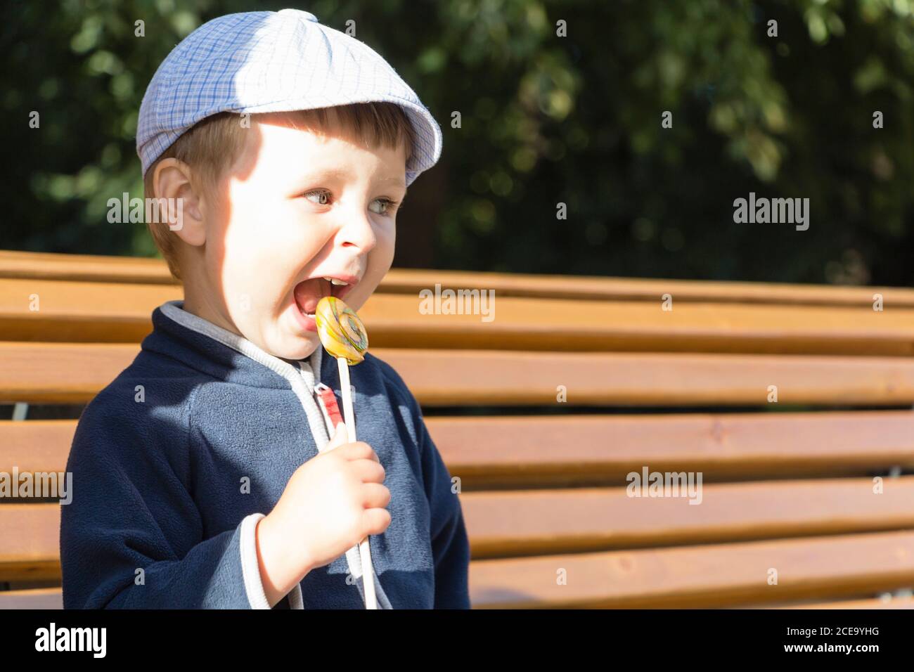 The boy is eating a delicious lollipop.A cute boy licks a lollipop ...
