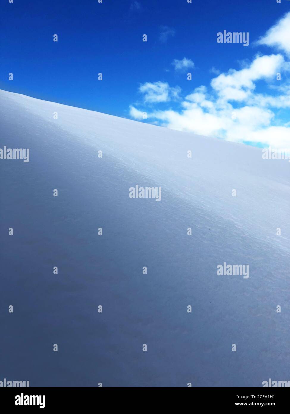 Snow with blue sky background with white clouds Stock Photo - Alamy