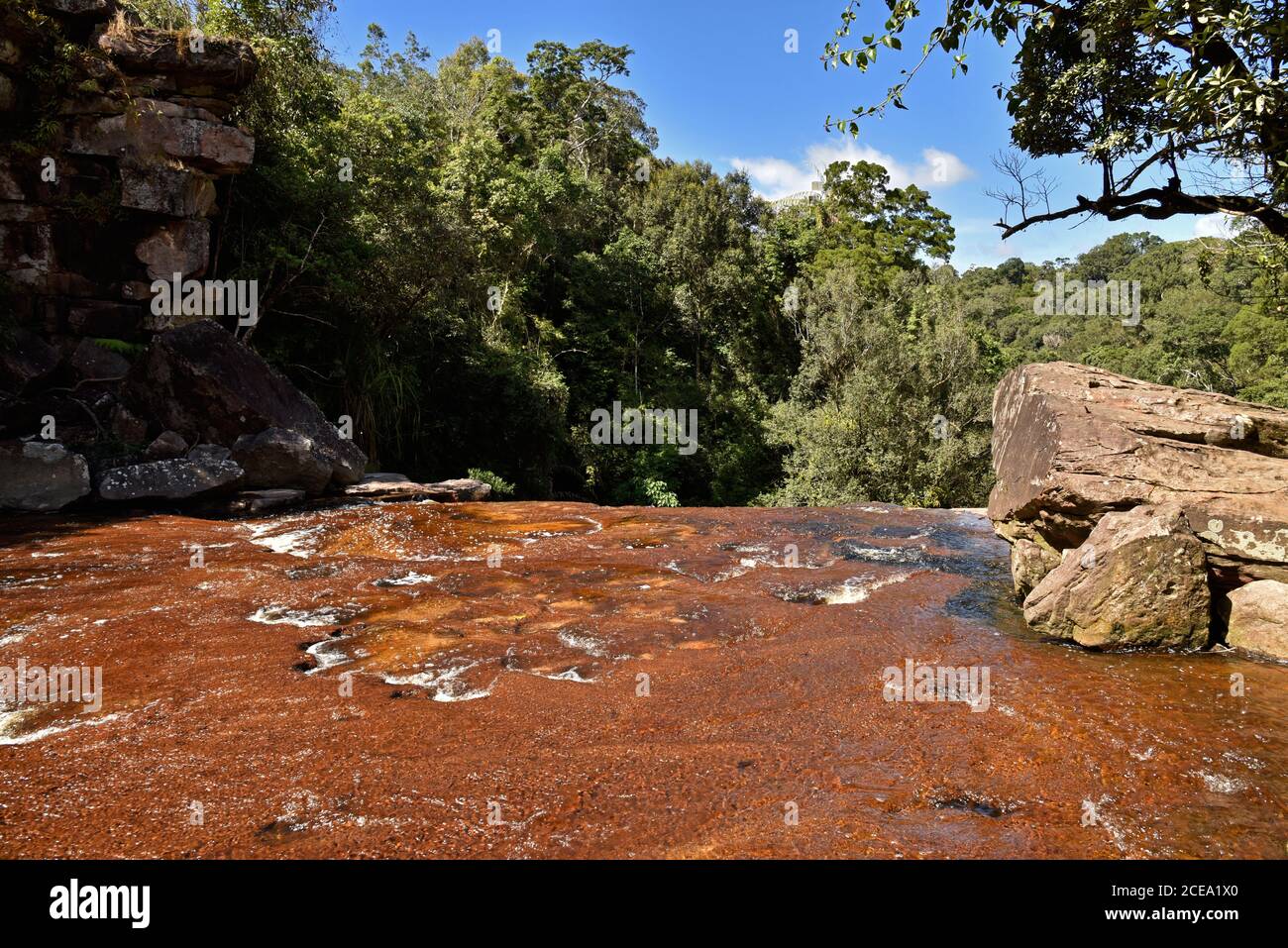 Popokvil waterfall, highlighting the orange color of the stones under ...