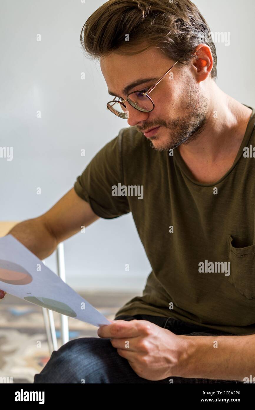 Young man looking diagrams in conference room Stock Photo - Alamy