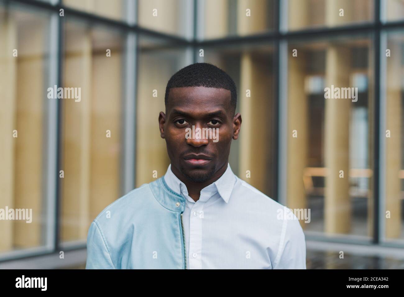Calm elegant ethnic male standing at wall Stock Photo - Alamy