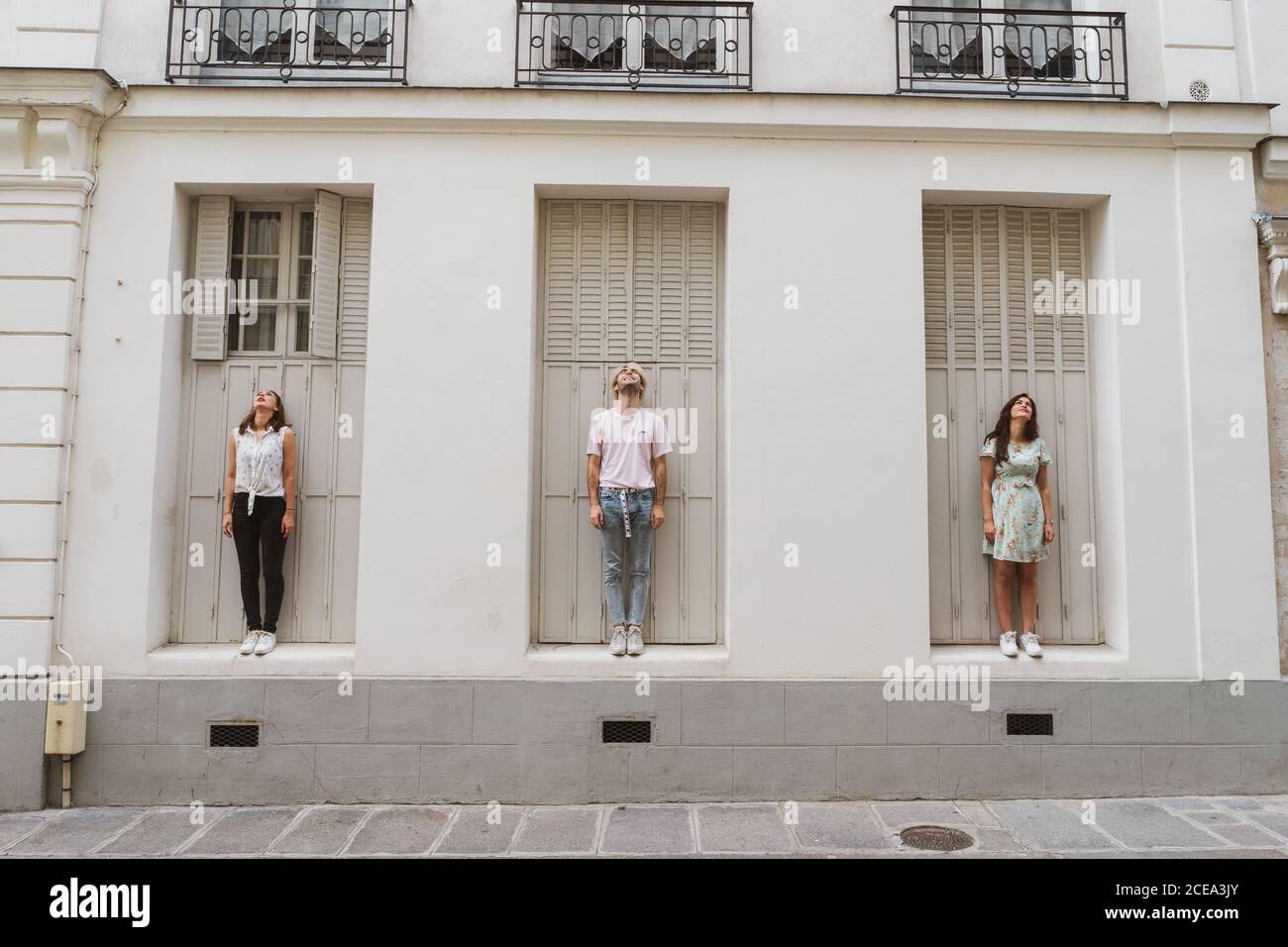 Friends standing on window sill Stock Photo - Alamy