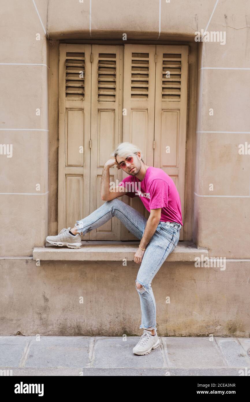 Stylish man sitting on window sill Stock Photo - Alamy