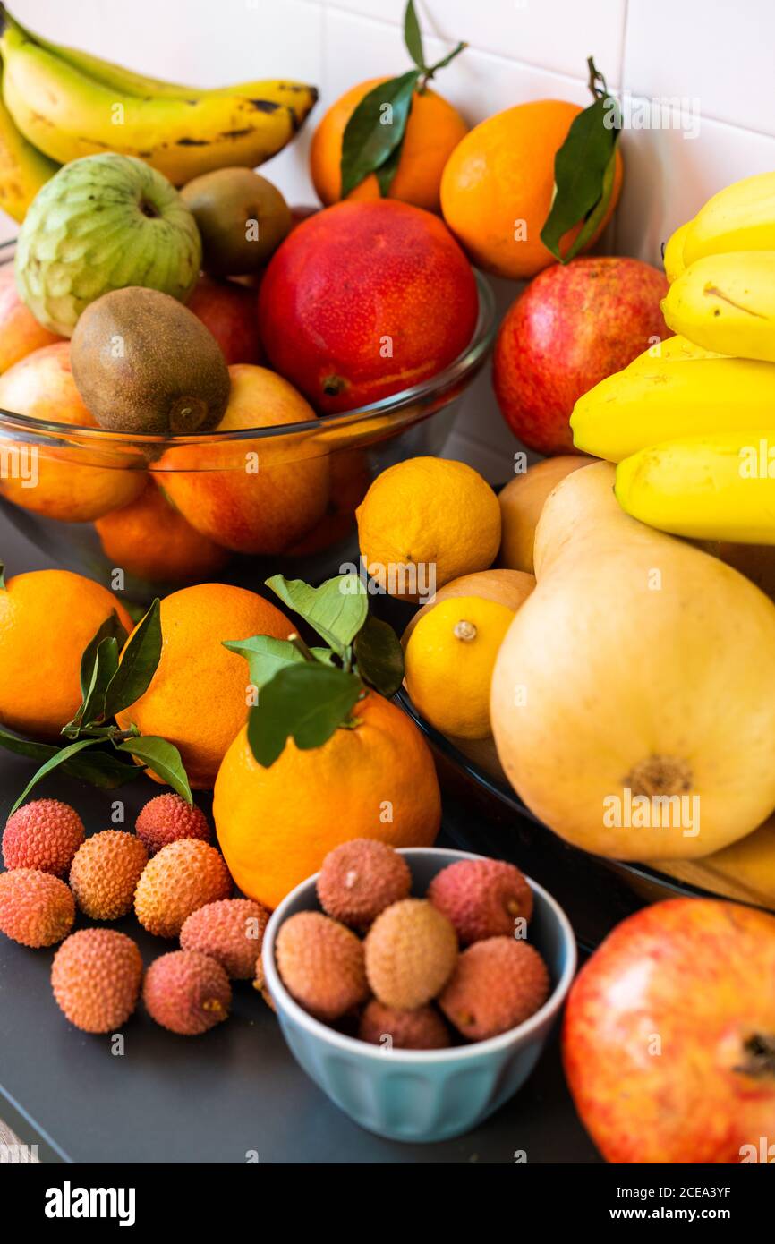 Collection of different fresh tasty ripe tropical fruits in bowls and ...