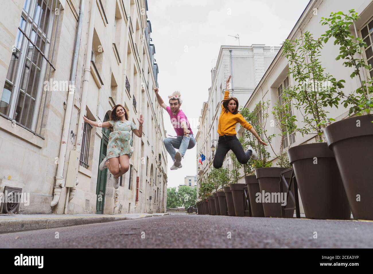 Happy friends jumping on street Stock Photo - Alamy