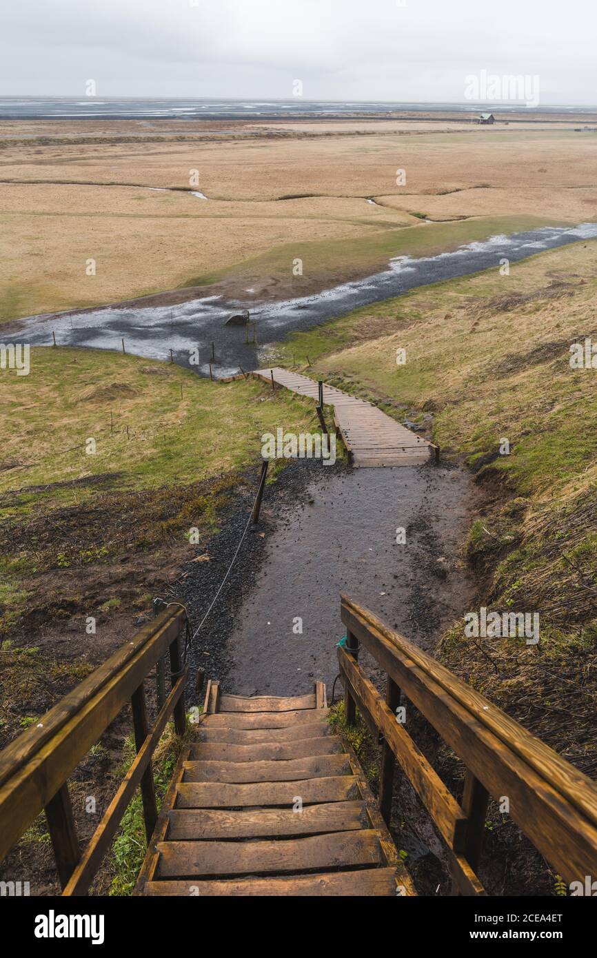 Steps of lumber stairway going down through amazing Icelandic ...