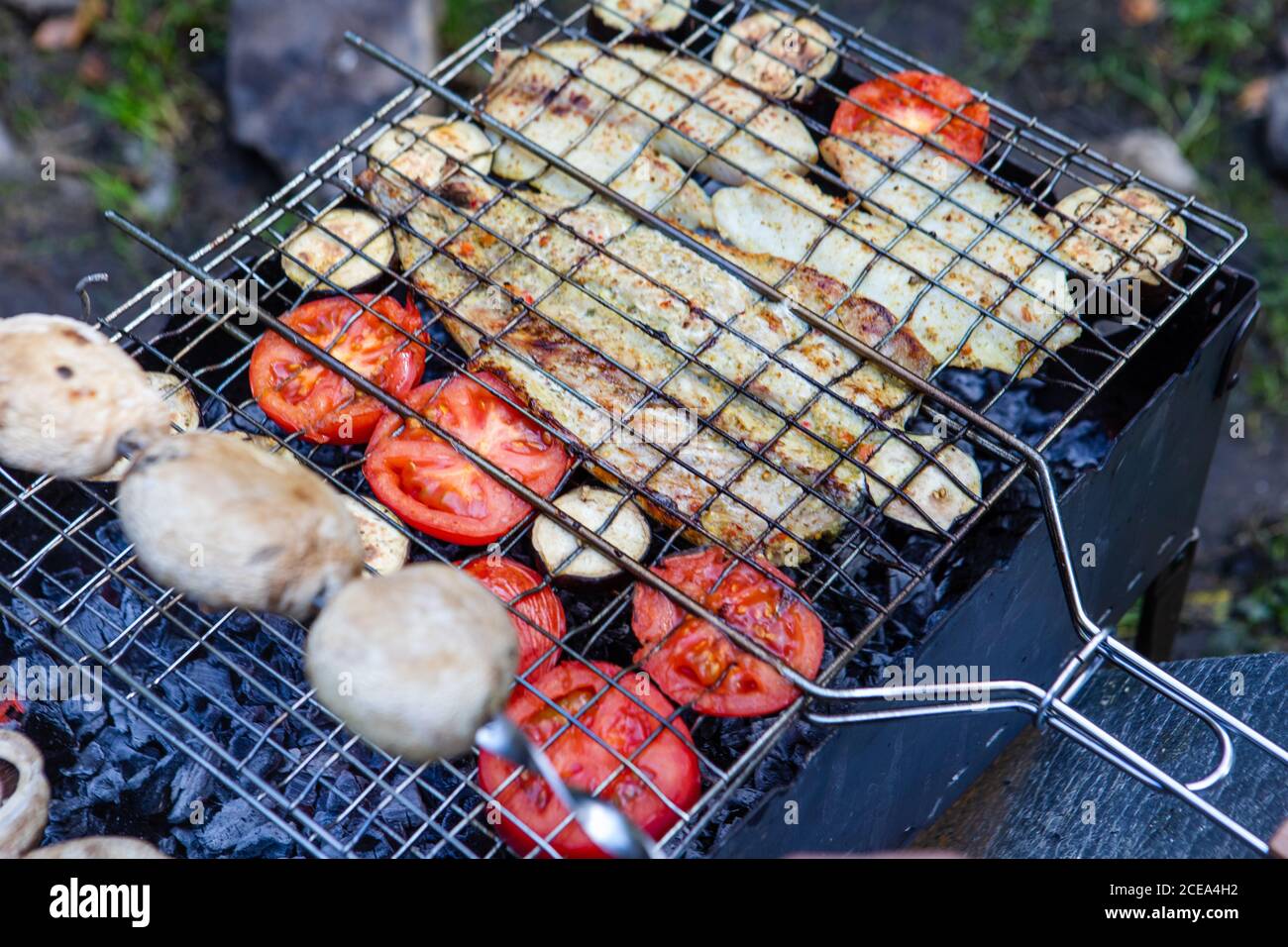 bbq concept fish on fire with mushroom and tomatoes Stock Photo - Alamy