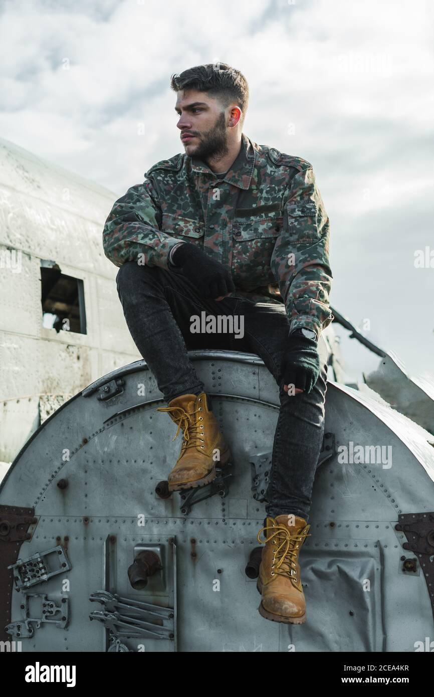 man sitting on plane carcass Stock Photo - Alamy