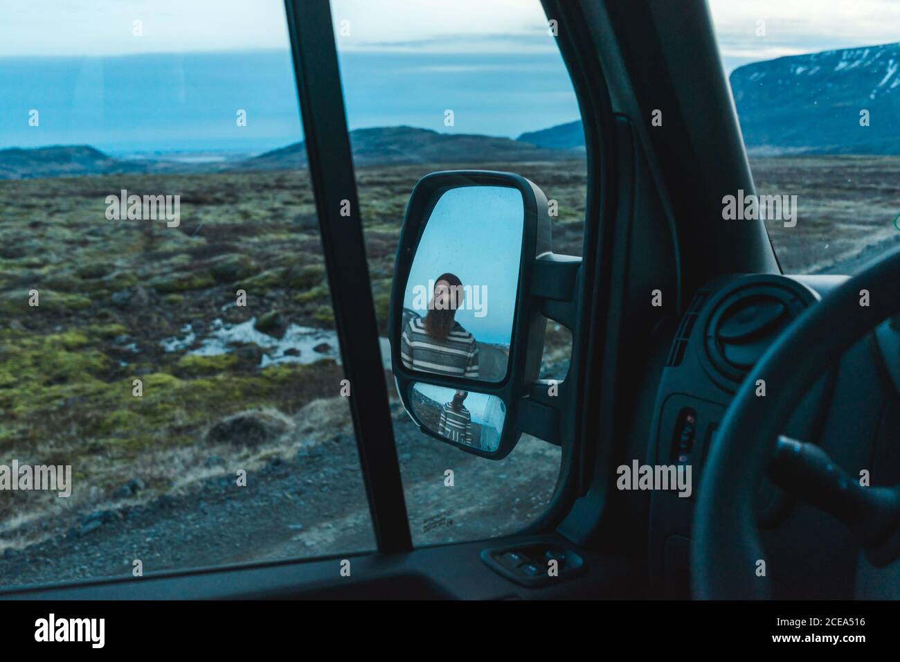 Reflection of handsome bearded man in rear-view mirror of car during ...