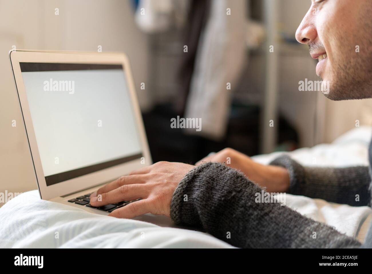man chilling on bed with laptop Stock Photo - Alamy