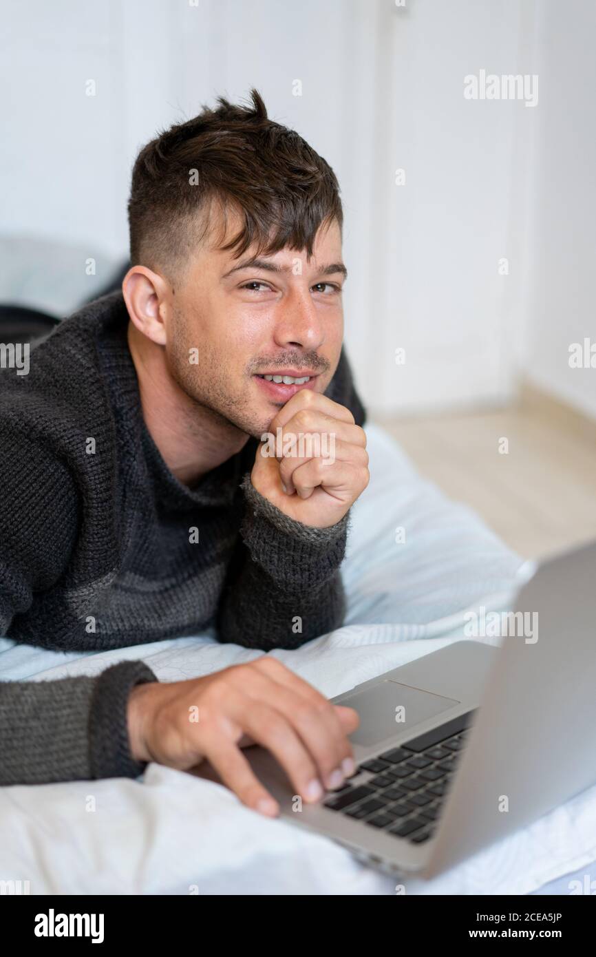 man chilling on bed with laptop Stock Photo - Alamy