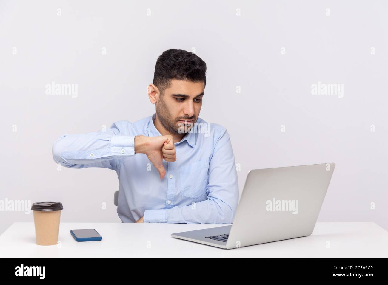 Dislike! Businessman sitting office workplace showing thumbs down ...