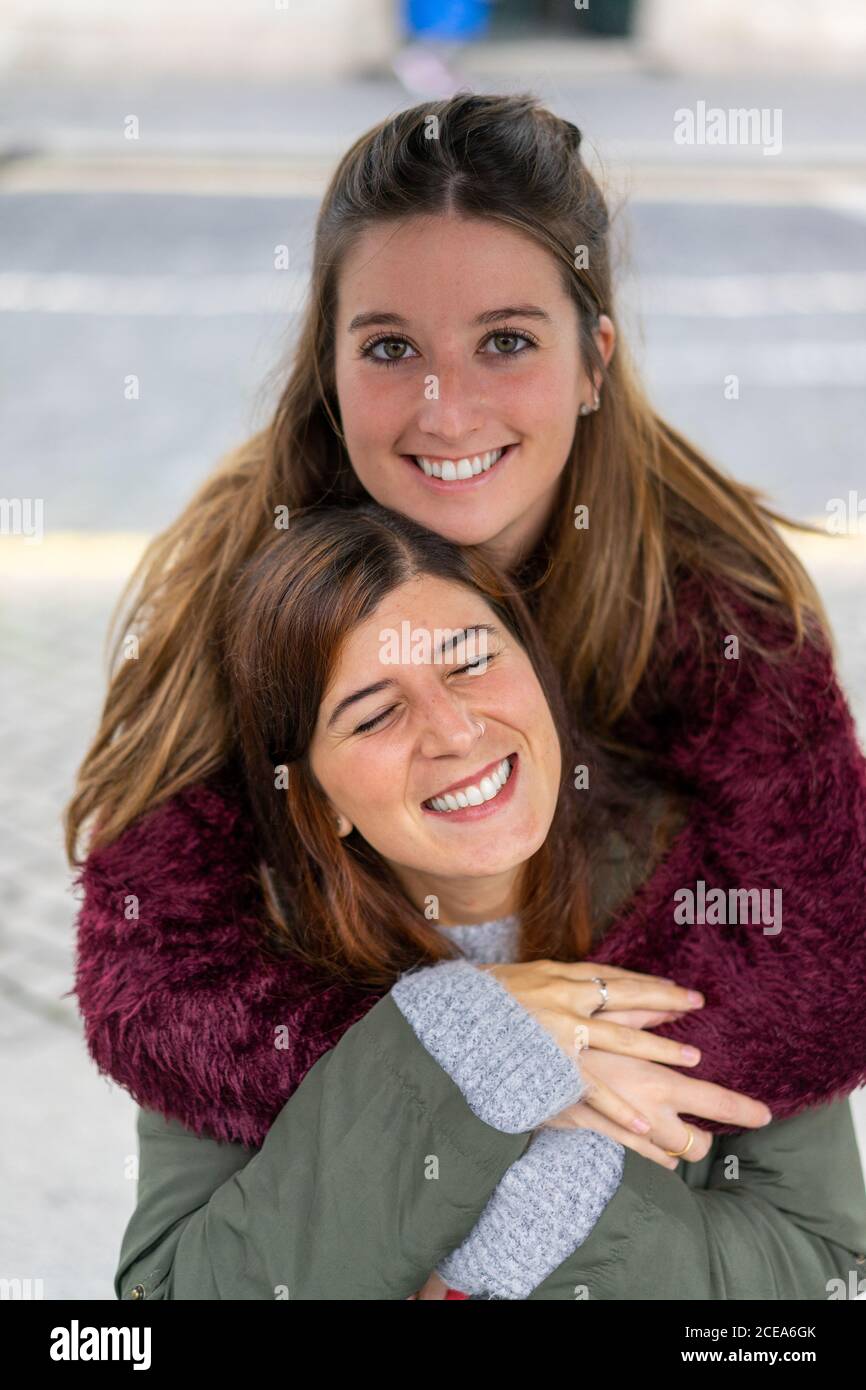 Lady hugging from back cheerful young attractive Woman Stock Photo - Alamy