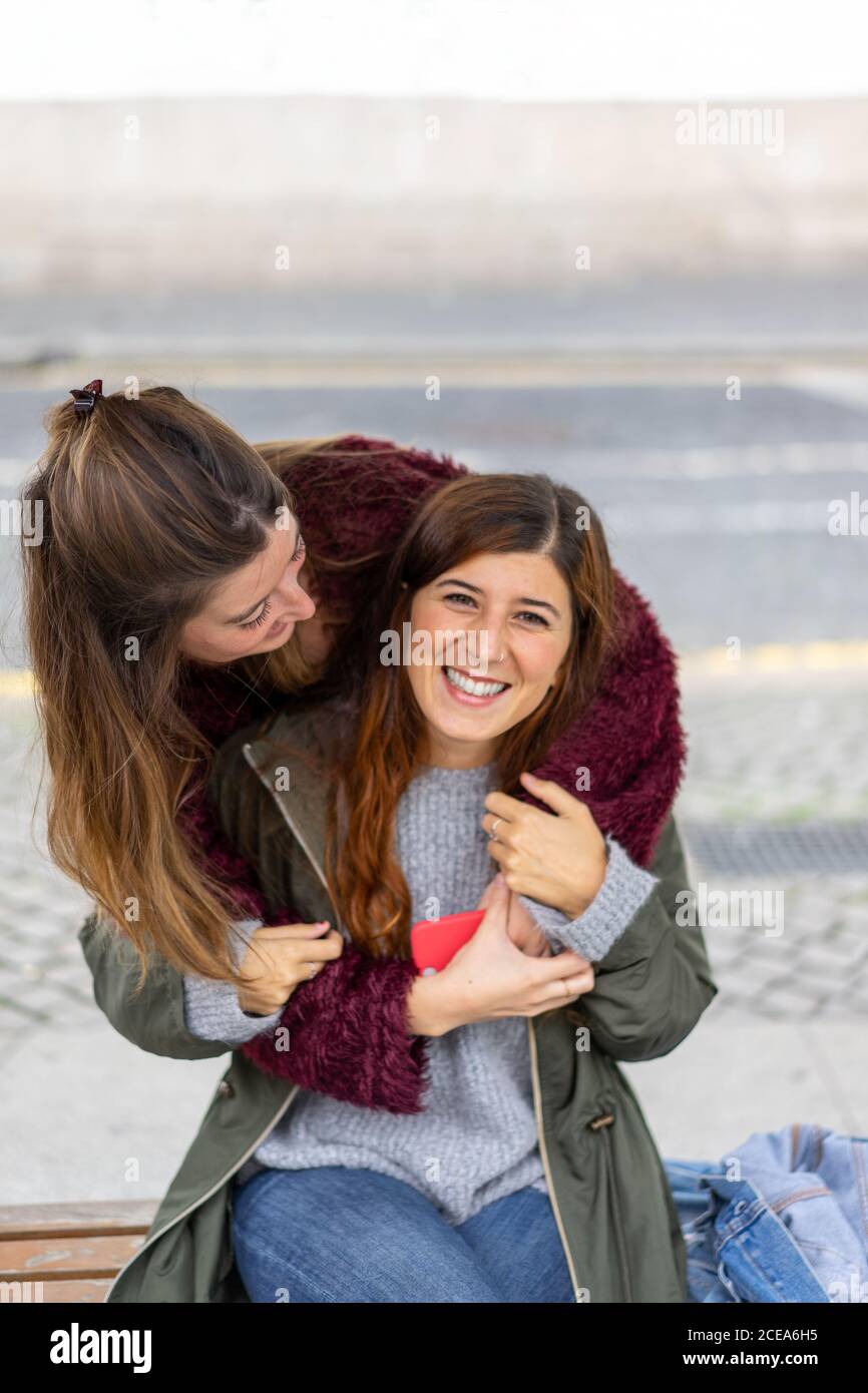 Lady hugging from back cheerful young attractive Woman Stock Photo - Alamy